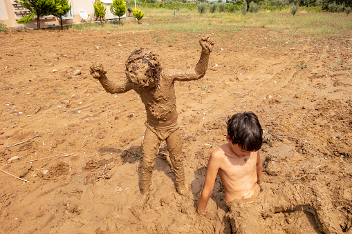 เด็กชายสองคนกําลังเล่นอยู่ในโคลน ภาพสต็อก ดาวน์โหลดรูปภาพตอนนี้