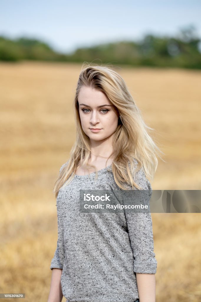 Portrait Of A Pretty Blond Teenage Girl In A Cornfield Bathed In Soft