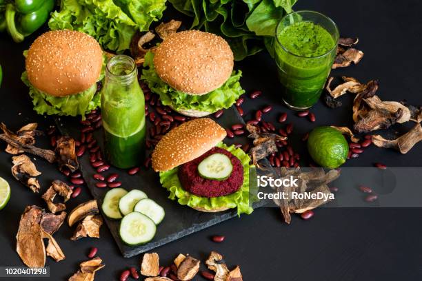 Burger Vegan Dengan Potongan Bit Dan Smoothie Hijau Di Latar Belakang