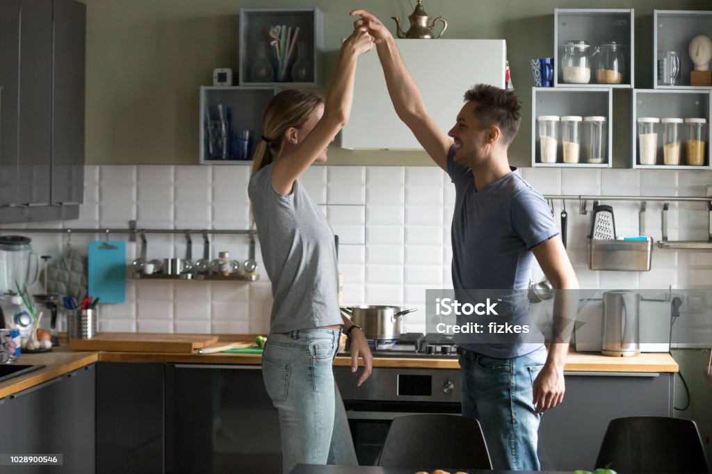 Happy Romantic Couple Dancing In The Kitchen While Cooking Together