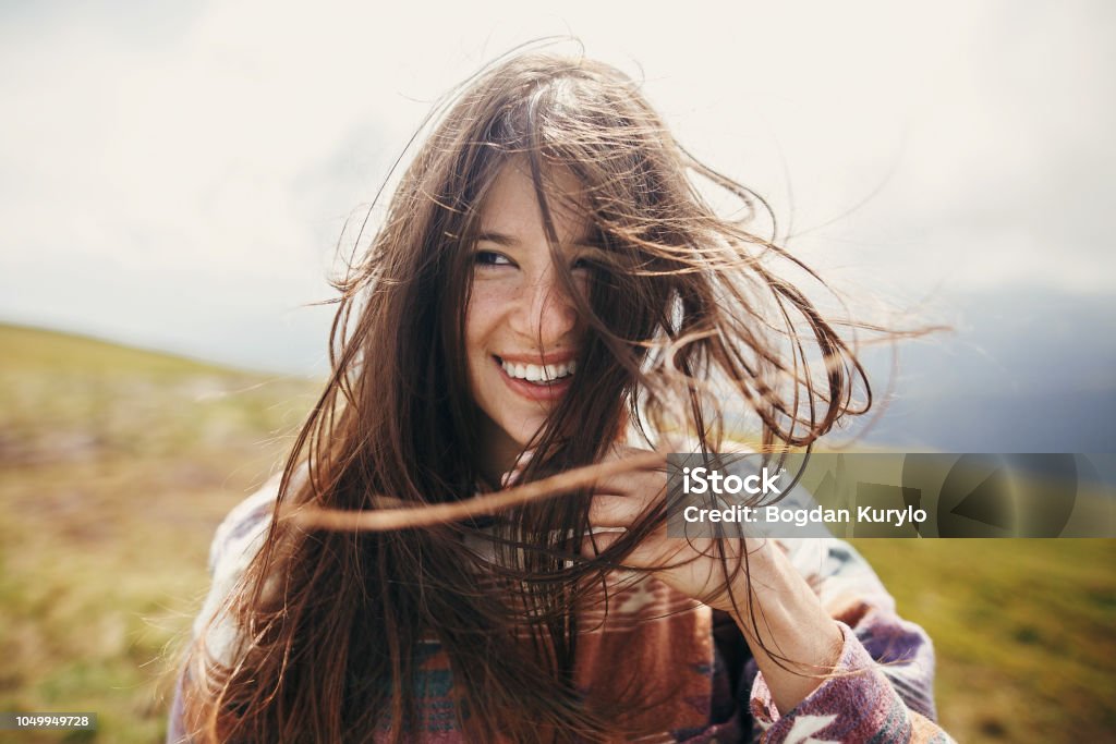 Happy Traveler Hipster Girl With Windy Hair And Smiling Standing On Top