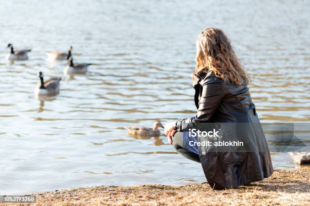 Photo Libre De Droit De Larrière De La Jeune Femme Assise Au Bord Du