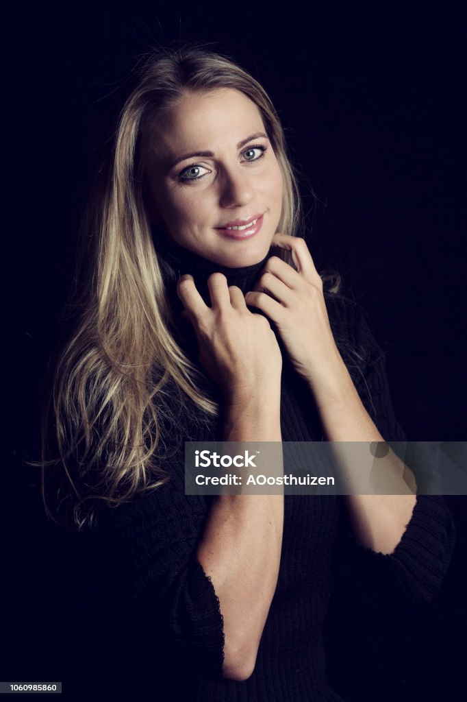 Beautiful Woman In Low Light Sitting On A Brown Leather Sofa Artistic