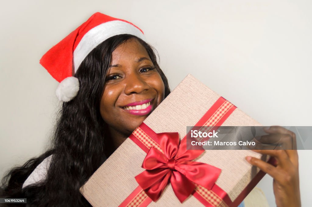 Portrait Of Young Happy And Beautiful Black African American Woman In Santa Claus Hat Holding