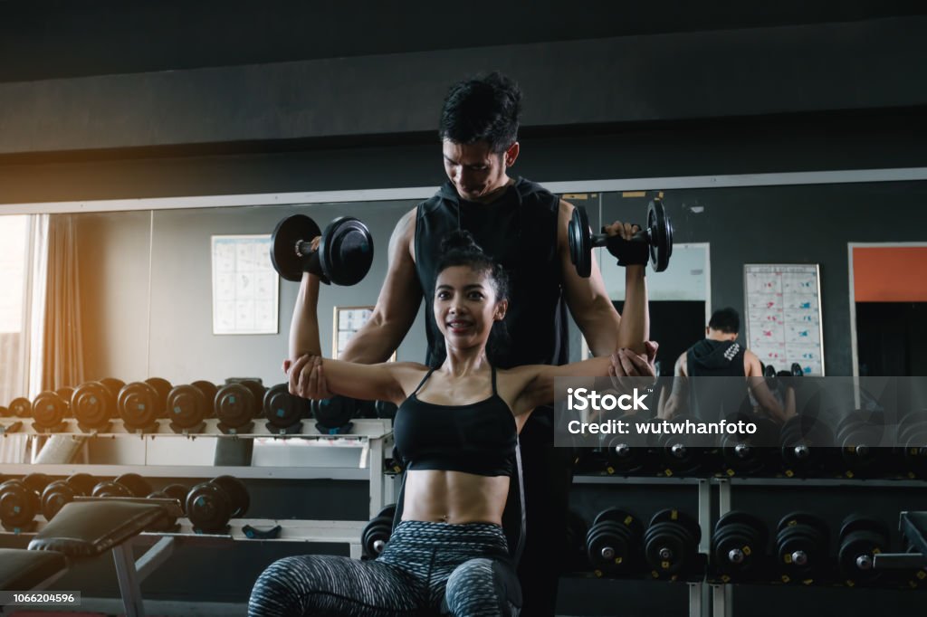 Personal Trainer Helping Woman Working Lift Heavy Dumbbells Two Hand