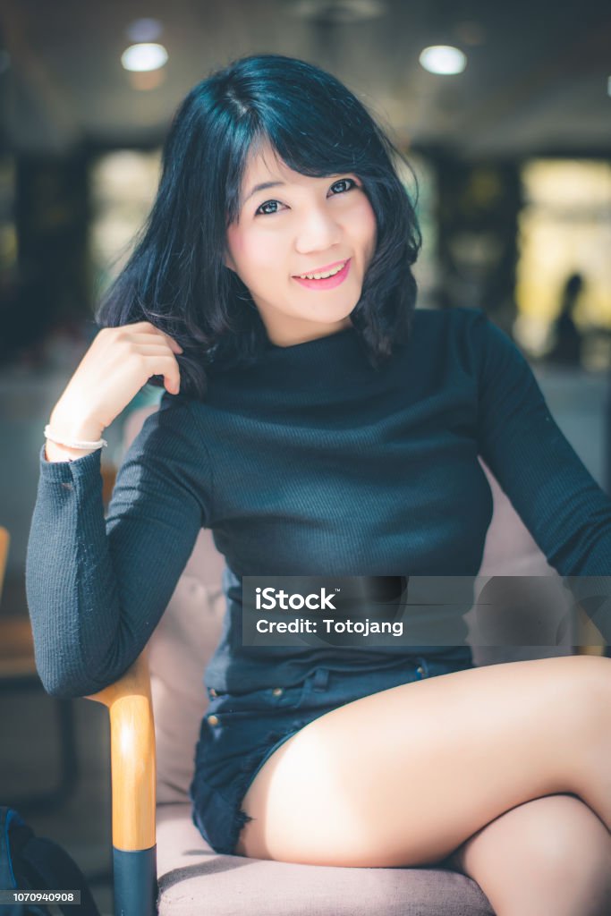 아름 다운 매력적인 젊은 아시아 여자와 카페에서 소파에 누워 휴식 시간 개념 아침에 커피가 게 배경 흐리게 개념에 대한 스톡