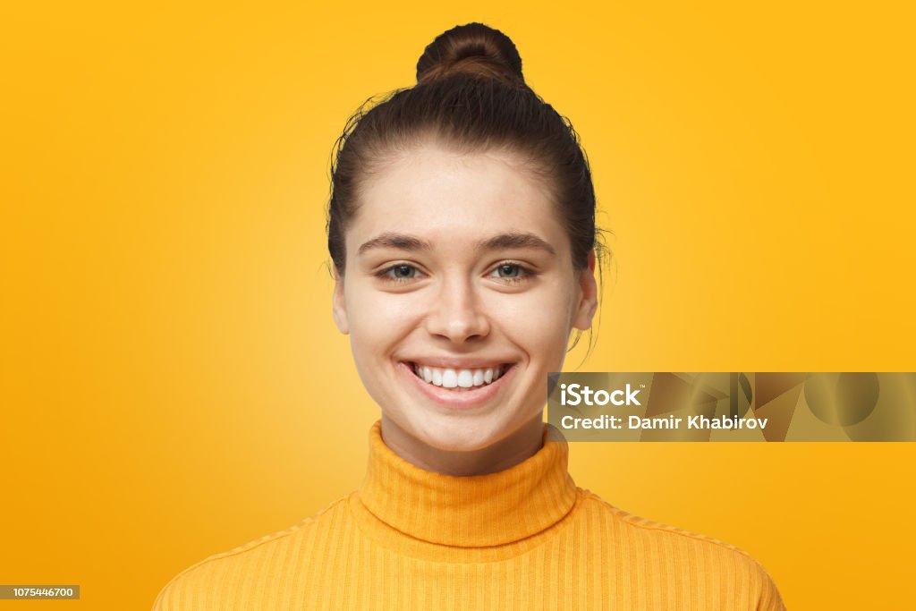 Close Up Portrait Of Smiling Pretty Girl Isolated On Yellow Background