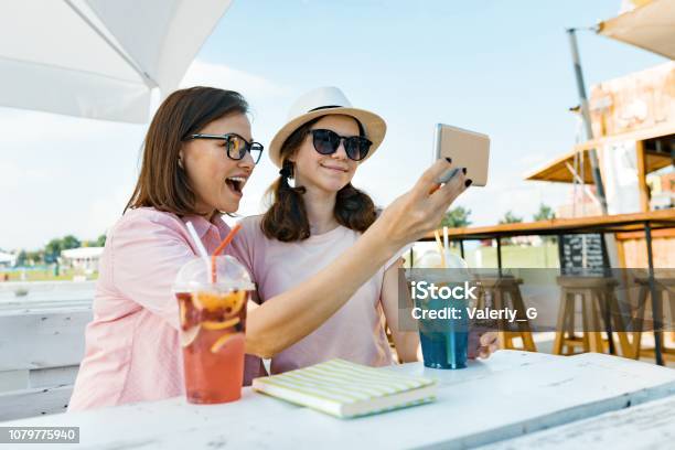 행복 한 엄마와 사춘기 딸 얘기 하 고 웃 고입니다 스마트폰에 걸릴 Selfie 뜨거운 여름 날에 차가운 음료를 즐기는 여름