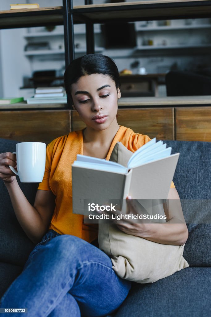 Beautiful Mixed Race Girl In Orange Shirt Holding Cup Of Tea And