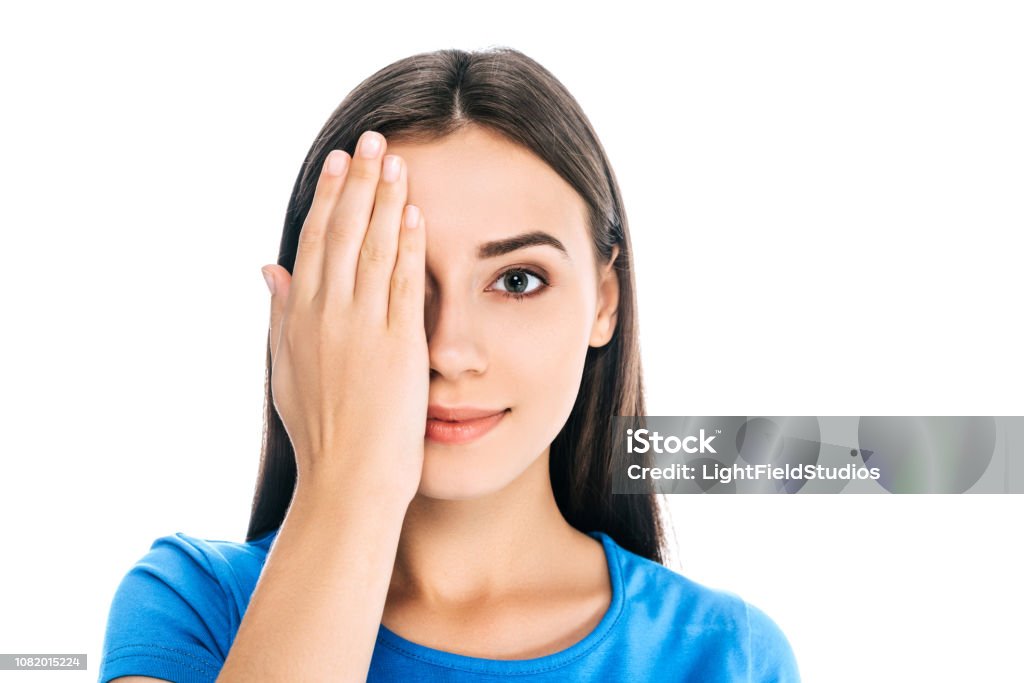 Obscured View Of Smiling Woman Covering Eye With Hand Isolated On White