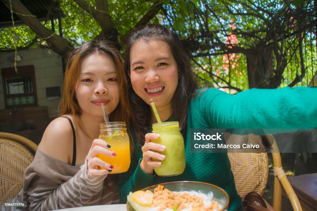 Lifestyle Portrait Of Two Young Happy And Cute Asian Chinese