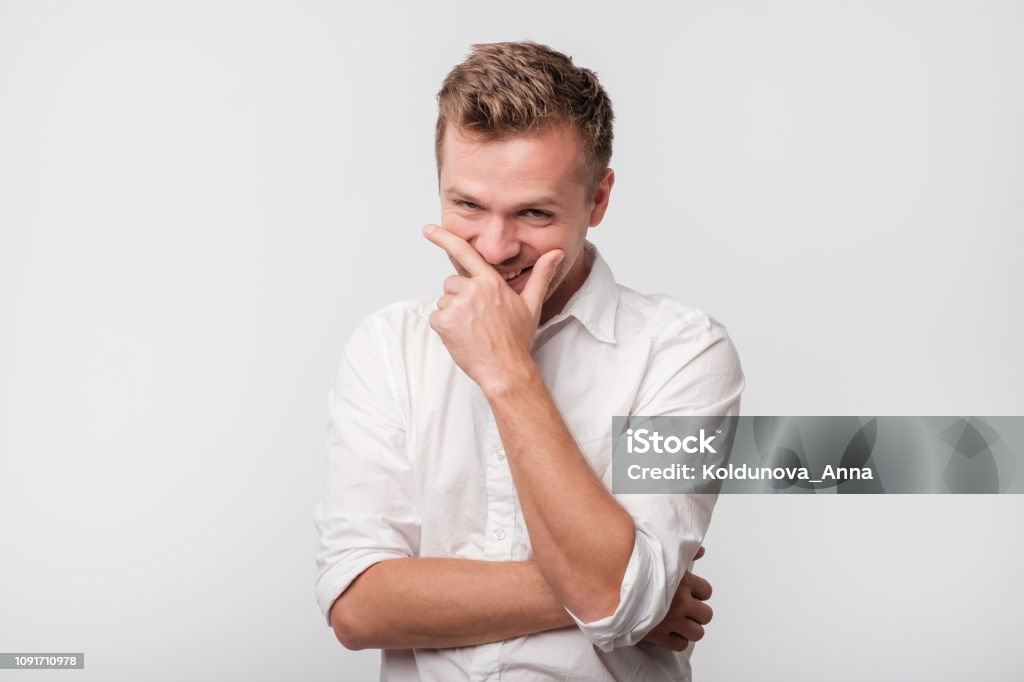Mature Man Laughing And Covering His Mouth With Hand Over White
