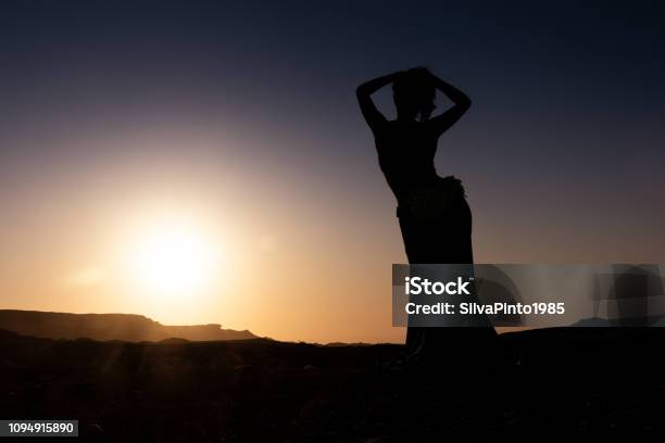 Woman Dancing To The Famous Arab Belly Dance With Sunset In The Arid Desert Plain Of Namibe
