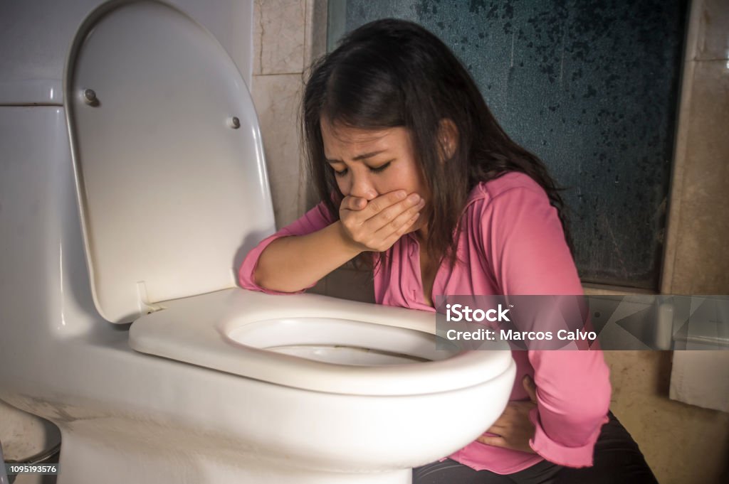 Young Drunk Or Pregnant Asian Woman Vomiting And Throwing Up In Toilet