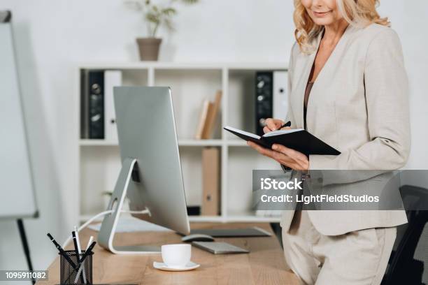 Memotong Bidikan Pengusaha Tersenyum Berdiri Dan Menulis Di Notepad Di ... Memotong Bidikan Pengusaha Tersenyum Berdiri Dan Menulis Di Notepad Di ...
