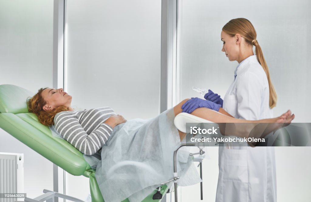 Doctor Preparing For Gynecological Examination Of Mature Woman Stock