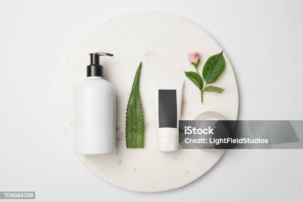 Top View Of Different Cosmetic Containers Aloe Vera Leaf And Rose