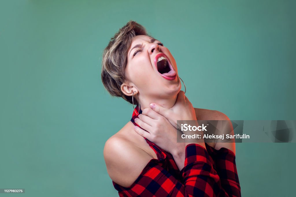 People And Emotions A Portrait Of Woman With Short Hair Choking Herself For Fun Holds Hands By