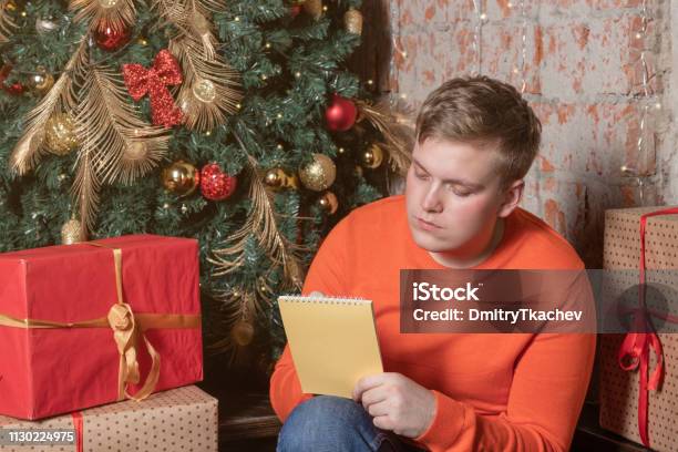 Pria Tampan Menulis Surat Untuk Santa Duduk Di Bawah Pohon Dikelilingi