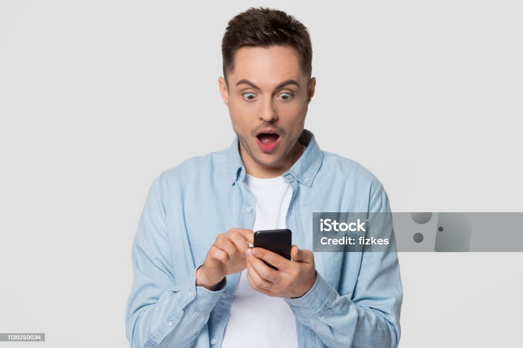 Surprised Guy Holding Cellphone Looking At Phone Shocked By News Stock