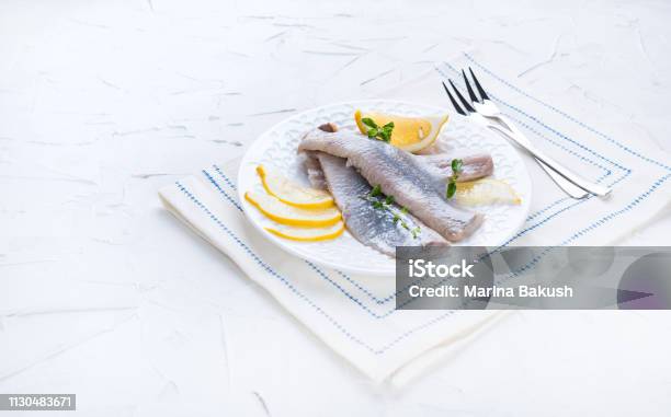 Fillet Ikan Haring Yang Diasinkan Di Piring Putih Dengan Lemon Dan