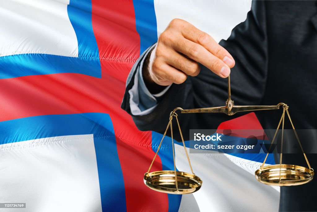 Judge Is Holding Golden Scales Of Justice With Faroe Islands Waving