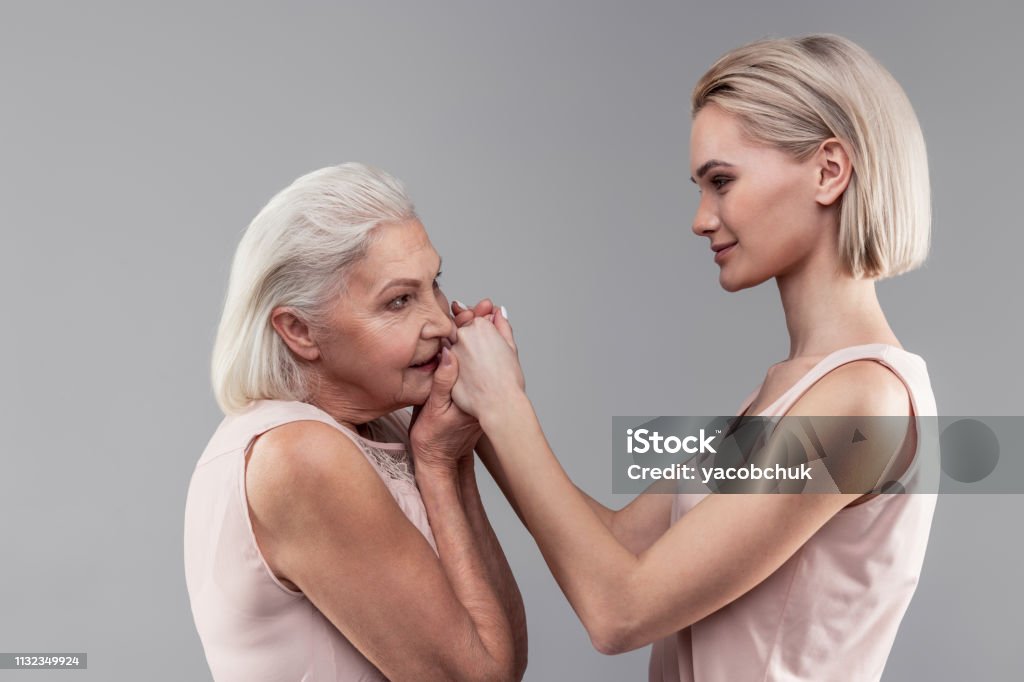 Greyhaired Pleasant Old Mother Hugging Hands Of Her Beaming Daughter
