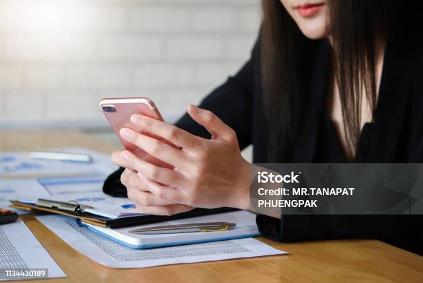 Wanita Bisnis Yang Menggunakan Smartphone Sambil Menulis Membuat