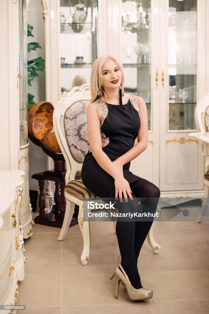 Stylish Elegant Blonde Woman In Beauty Rich Interior Wearing Black