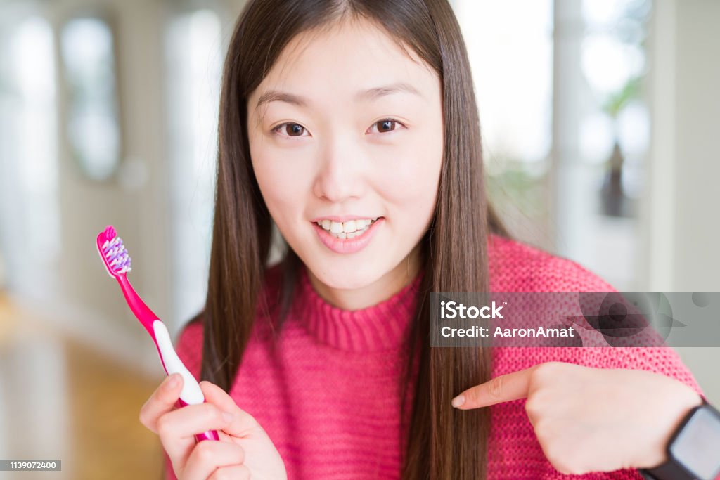 Beautiful Asian Woman Holding Toothbrush With Surprise Face Pointing