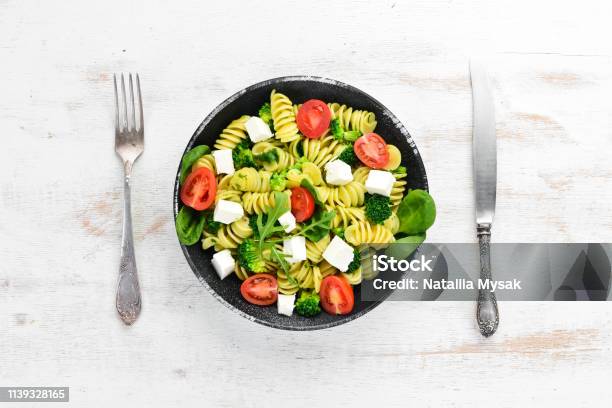 Pasta Dengan Bayam Tomat Dan Keju Feta Dalam Piring Hitam Di Latar