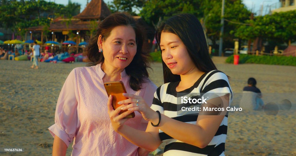 Young Happy And Pretty Asian Chinese Girl On The Beach Taking Selfie