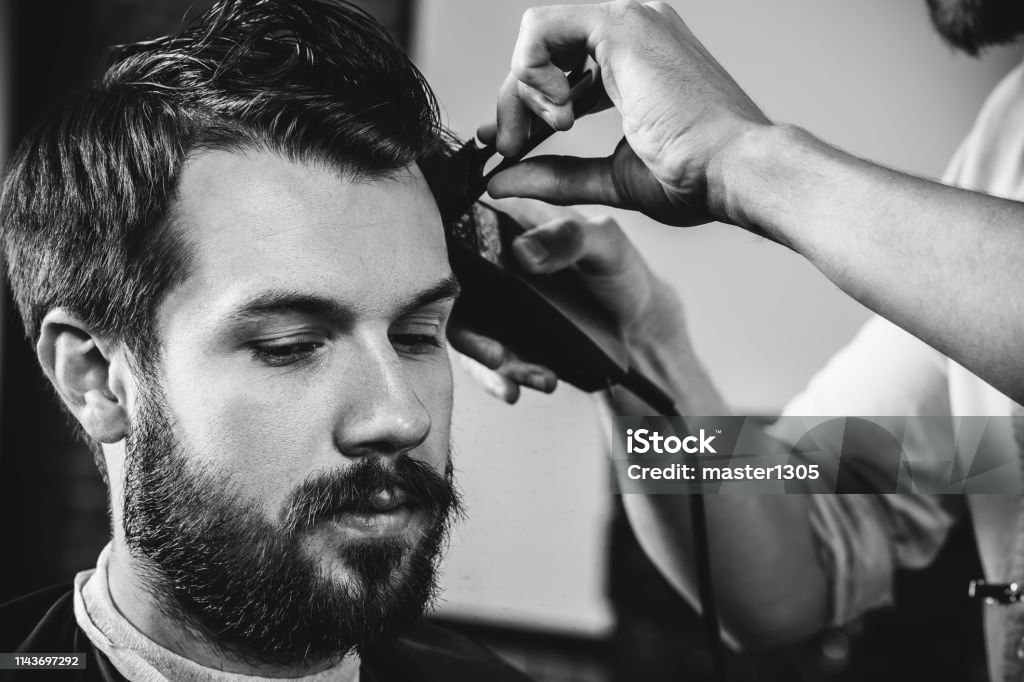 Young Handsome Barber Making Haircut For Attractive Man In Barbershop