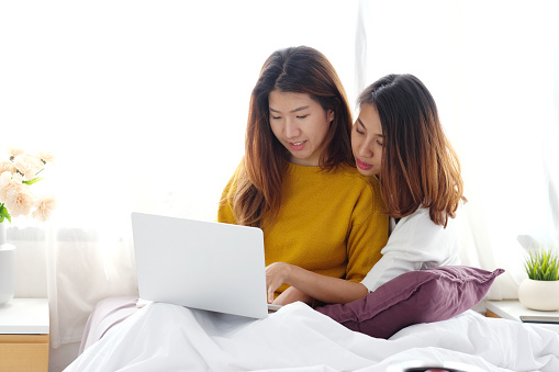 Young Cute Asia Woman Lesbian Couple Using Laptop Computer With