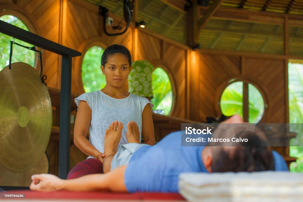 Young Beautiful And Exotic Asian Balinese Wellness Therapist Giving Body Thai Massage To