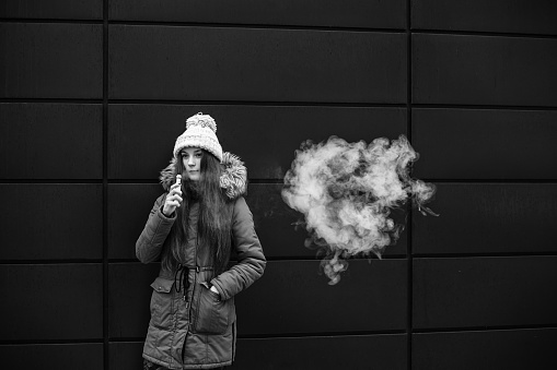 Vape Teenager Young Pretty White Girl Smoking An Electronic Cigarette Opposite Modern Background