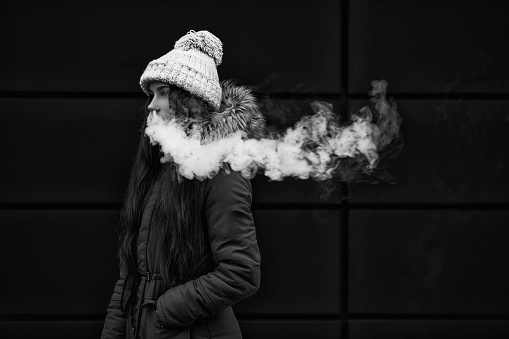Vape Teenager Young Pretty White Girl Smoking An Electronic Cigarette Opposite Modern Background