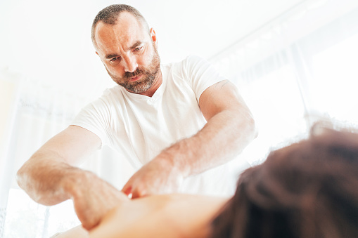 Bearded Masseur Man Doing Massage Manipulations On The Scapula Area