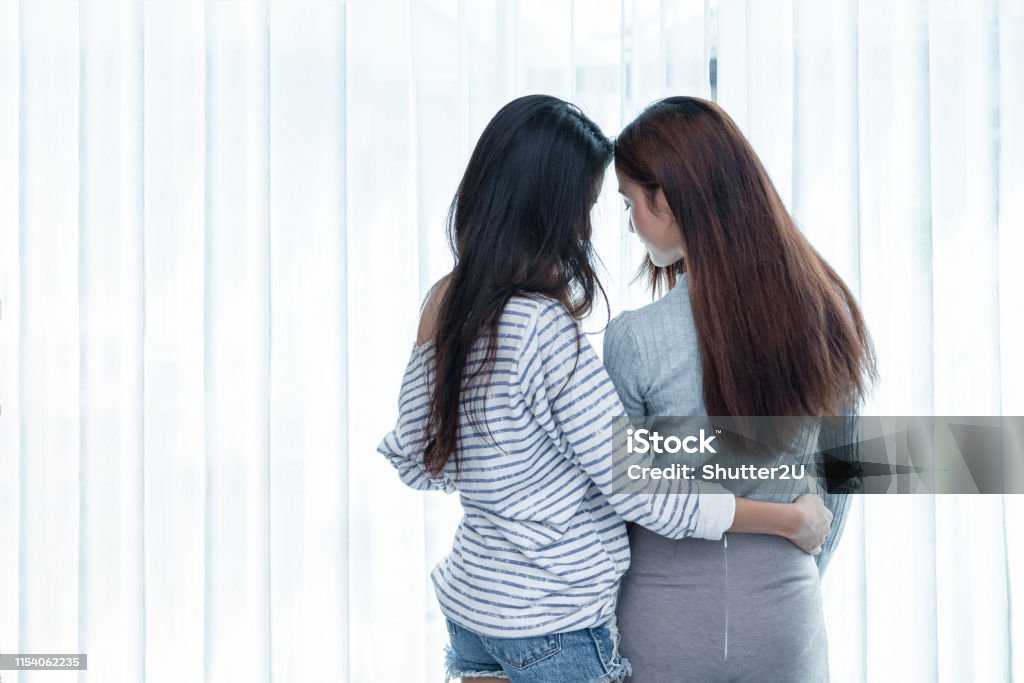 Two Asian Lesbian Women Looking Together In Bedroom Couple People And