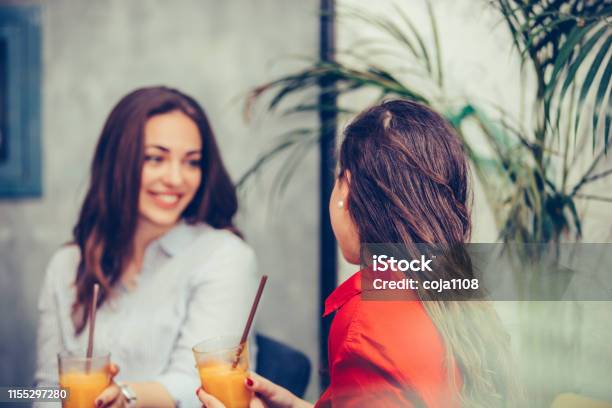 Dua Wanita Muda Yang Bahagia Berbicara Dan Minum Jus Buah Segar Di Kafe ... Dua Wanita Muda Yang Bahagia Berbicara Dan Minum Jus Buah Segar Di Kafe ...
