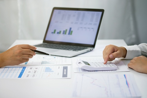 Pebisnis Menganalisis Grafik Investasi Dan Menekan Tombol Kalkulator