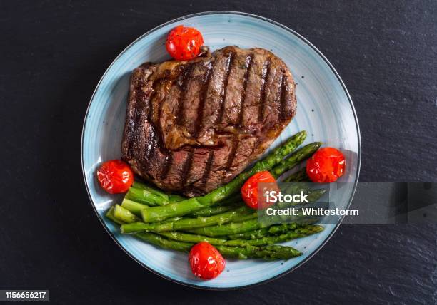 Daging Sapi Panggang Steak Ribeye Dengan Tomat Ceri Dan Asparagus Foto