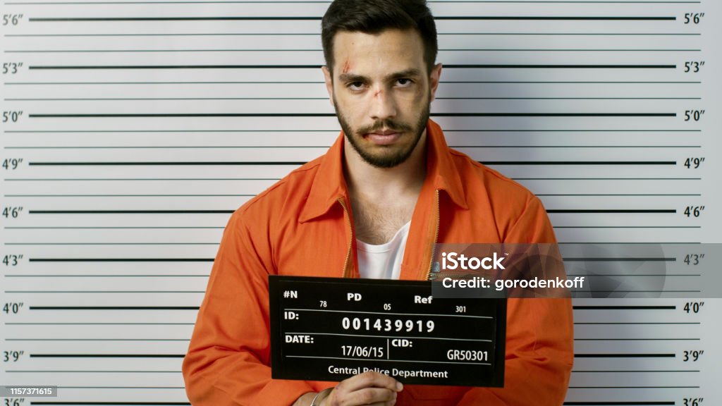 In A Police Station Arrested Man Getting Frontview Mug Shot Hes Wearing