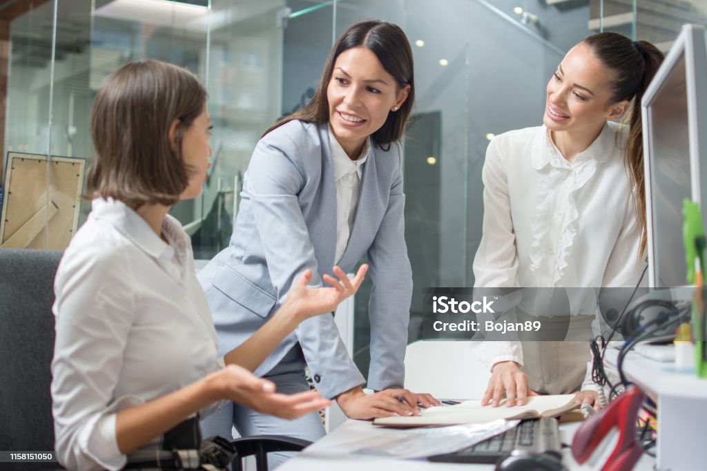 Group Of Three Beautiful Business Women Discussing Project At