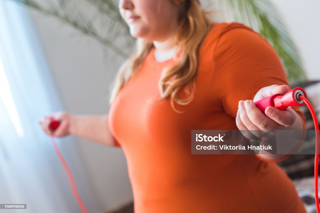 Chubby Woman Sport At Home Standing With Jumping Rope Closeup Stock