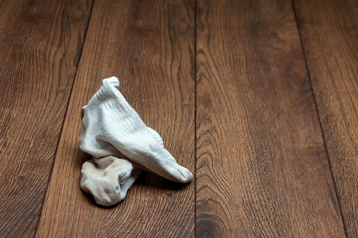 A Young Man Holds His Smelly Socks And Covers His Nose With His Hand ... A Young Man Holds His Smelly Socks And Covers His Nose With His Hand ...
