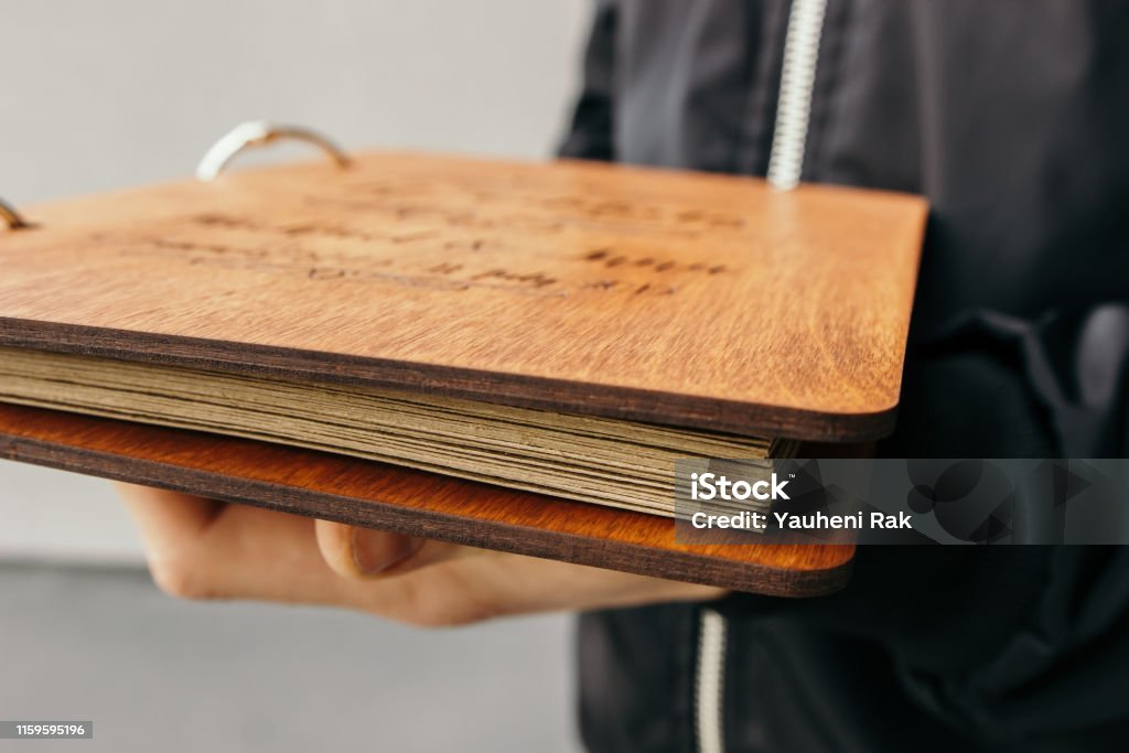 Bir Adamın Elinde Tahta Kapağı Olan Bir Kitap Adam Tahta Kapağı Olan