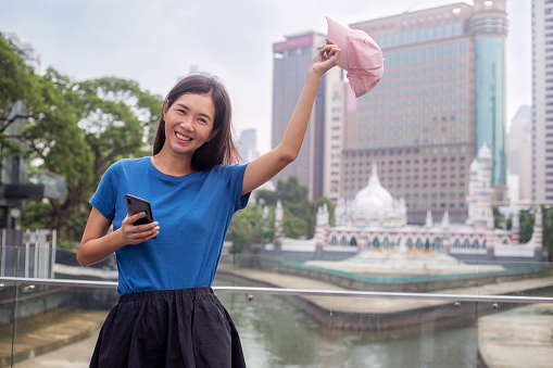 Bahagianya Wanita Asia Lepas Topi Sambil Jalanjalan Di Kota Kuala ... Bahagianya Wanita Asia Lepas Topi Sambil Jalanjalan Di Kota Kuala ...