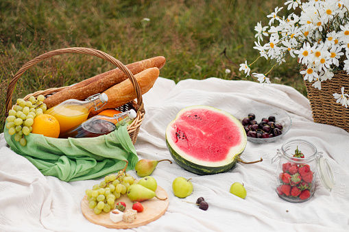 Summer Picnic In The Meadow On The Green Grass Fruit Basket Juice And Bottled Wine Watermelon