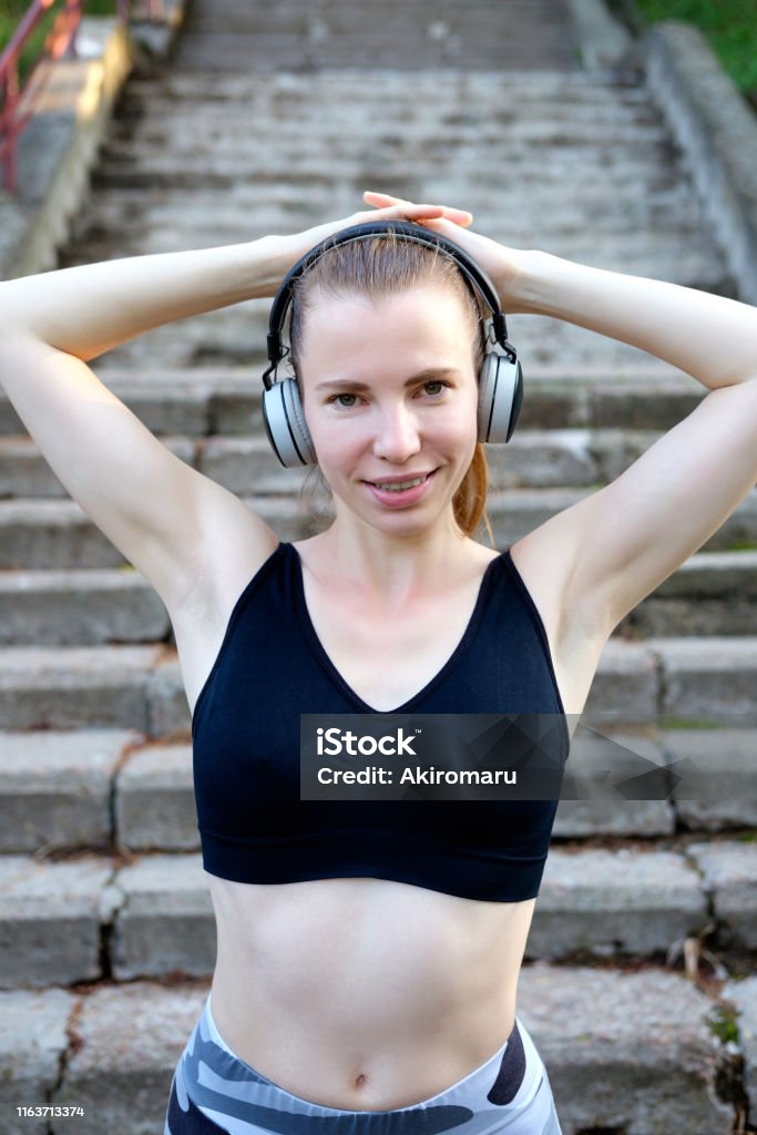 Portrait Of Young Attractive Smiling Athletic Girl Standing Near Stairs